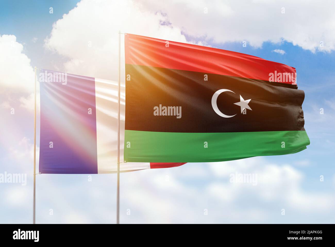 Sunny blue sky and flags of libya and france Stock Photo - Alamy