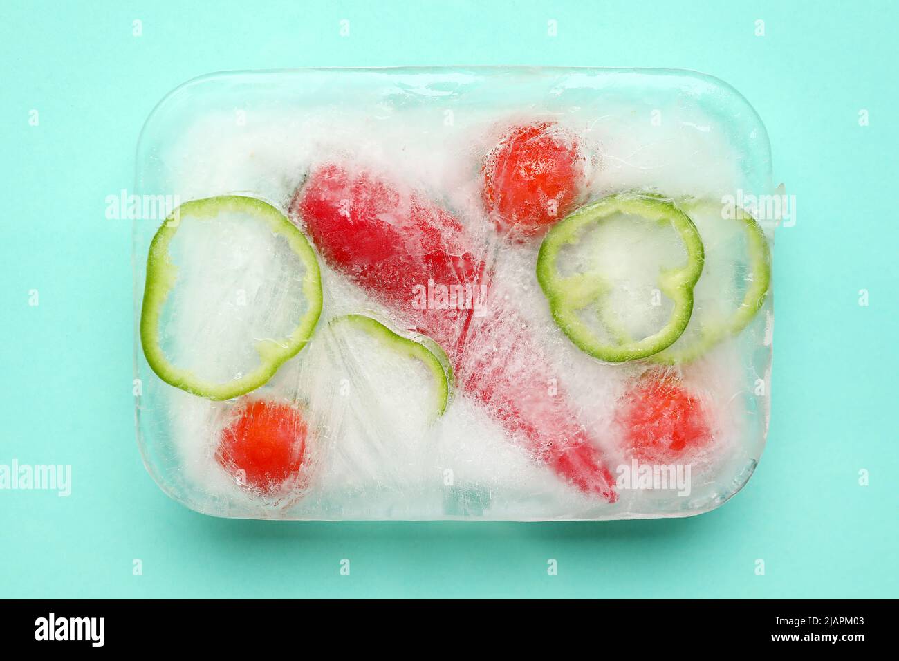 Fresh cut vegetables frozen in ice on turquoise background Stock Photo ...