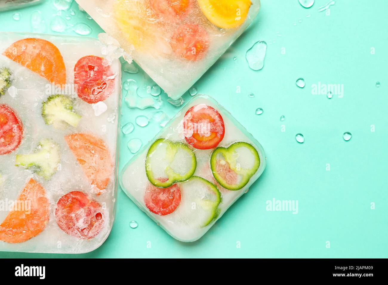Fresh cut vegetables frozen in ice on turquoise background Stock Photo ...