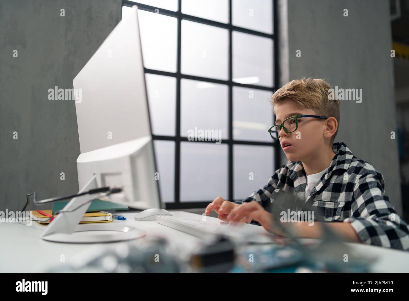 Schoolboy using computer in classroom at school Stock Photo - Alamy