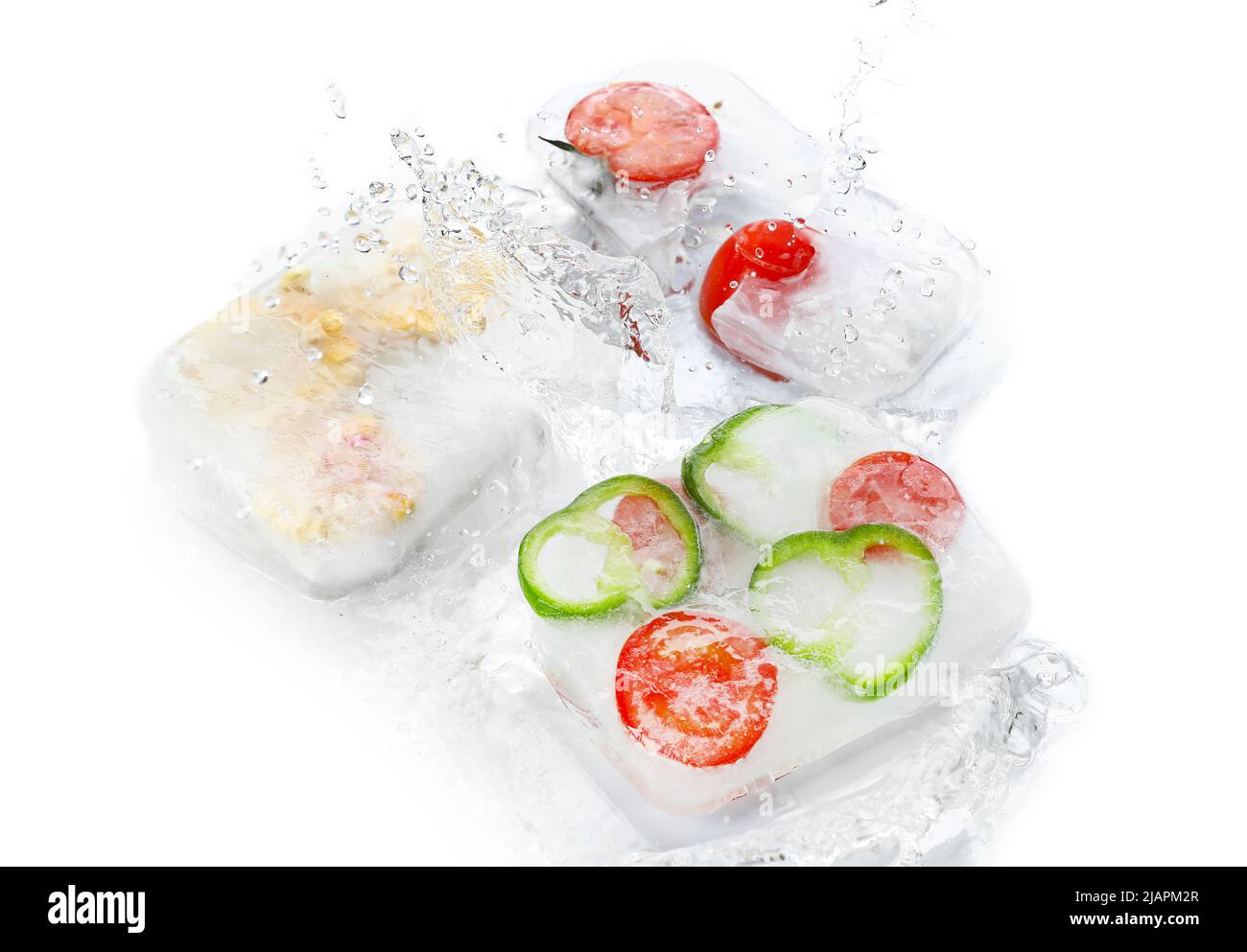 Fresh vegetables frozen in ice with splash of water on white background ...