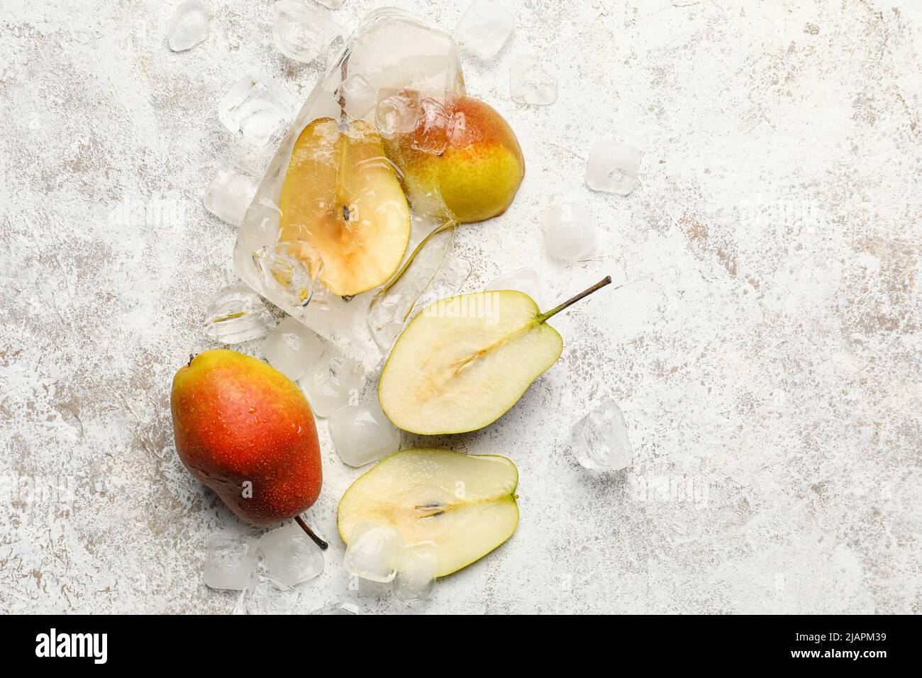 Fresh pear frozen in ice on light background Stock Photo - Alamy