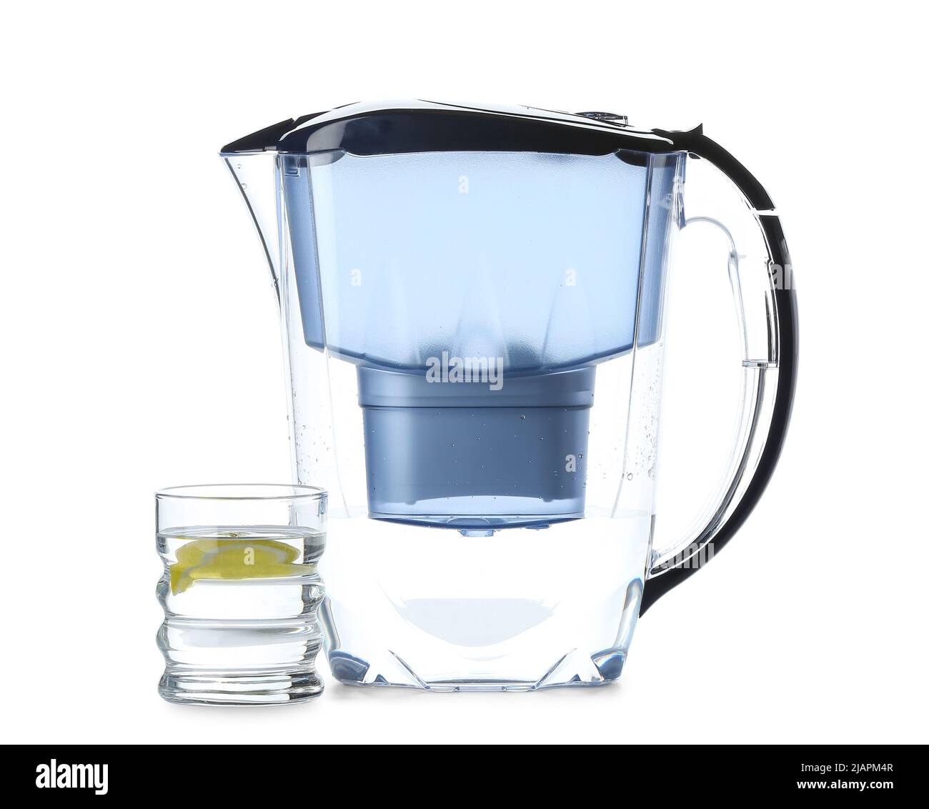 Filter jug and glass of water with lemon slice on white background ...