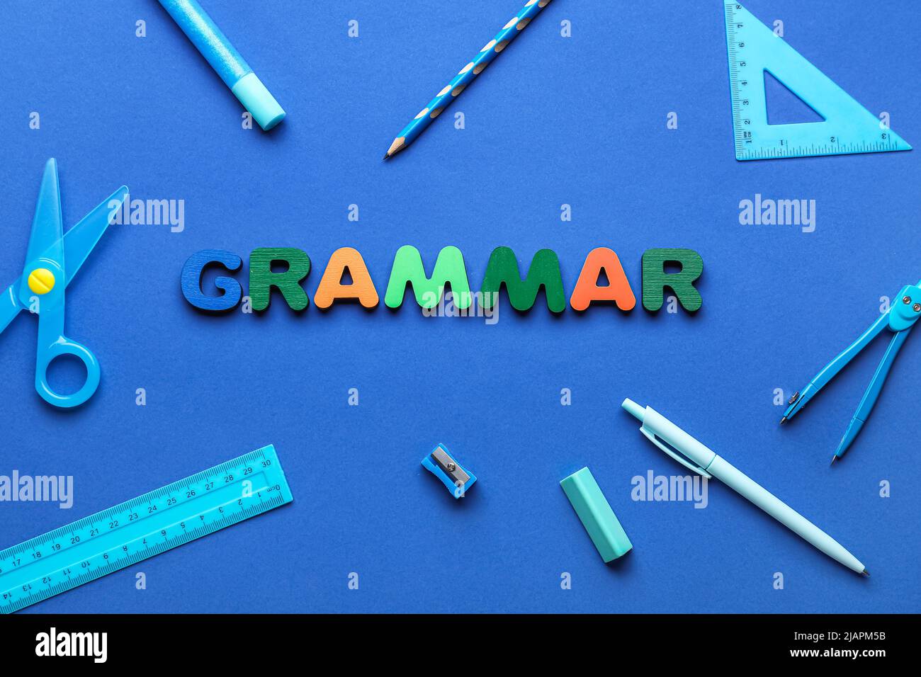 Word GRAMMAR and stationery supplies on blue background Stock Photo - Alamy