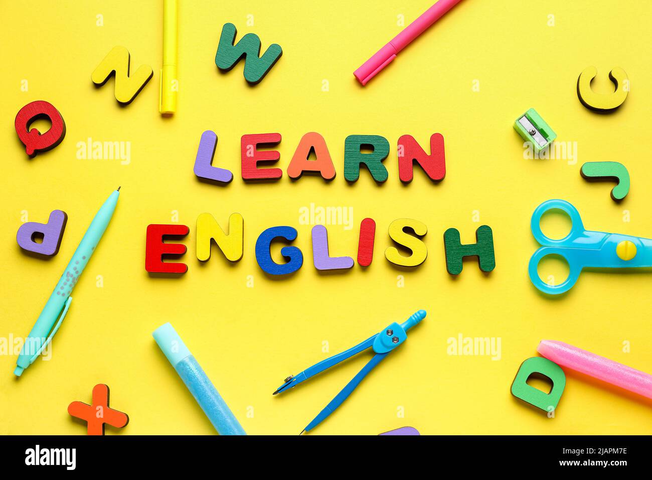 Text LEARN ENGLISH with letters and stationery on yellow background ...
