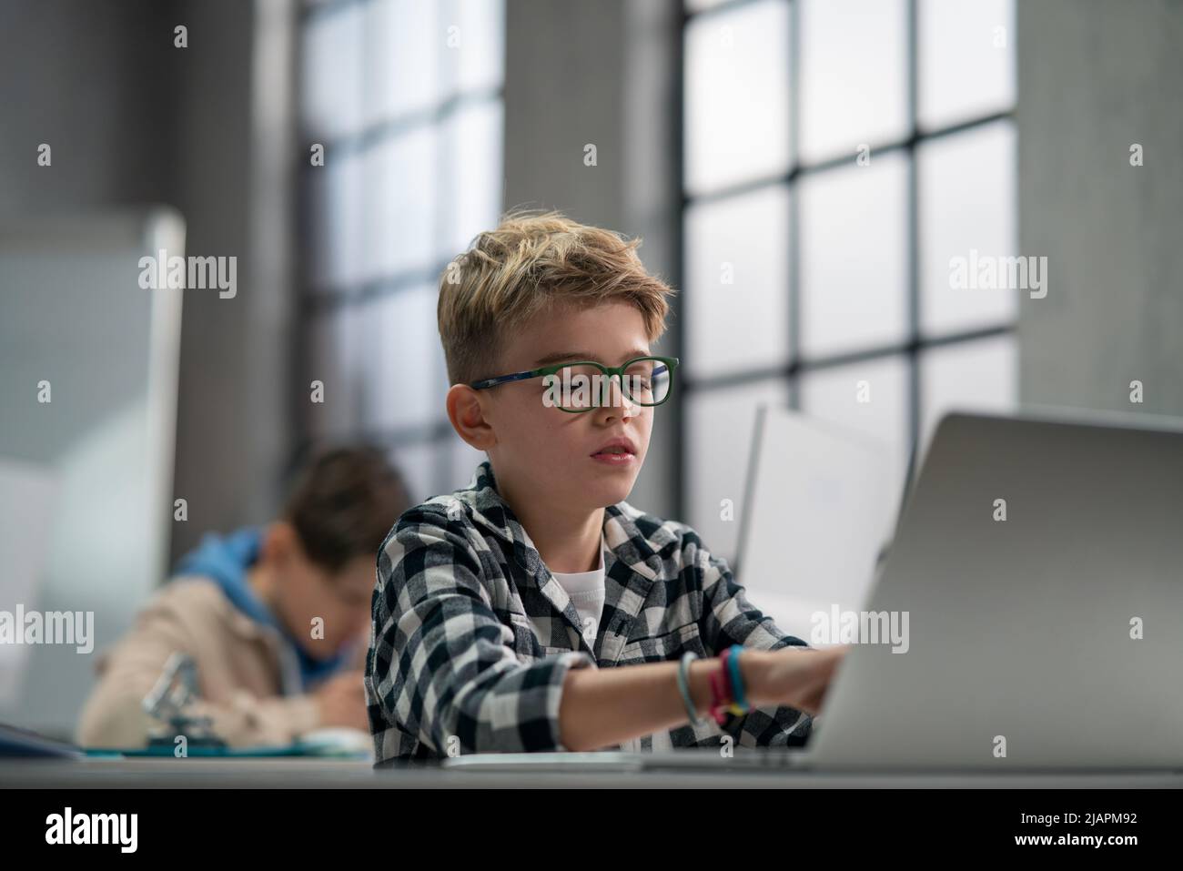 Schoolboy using computer in classroom at school Stock Photo - Alamy