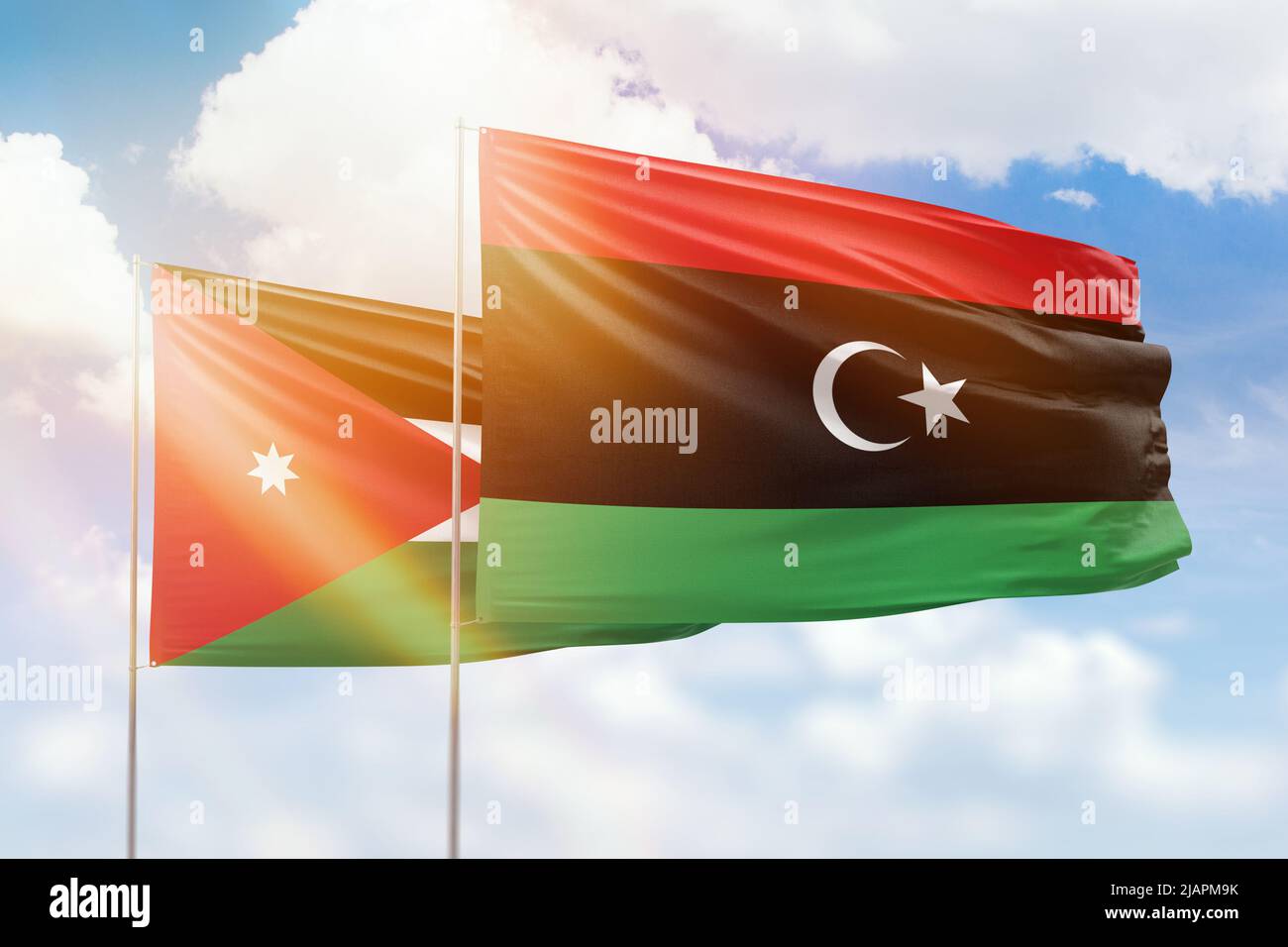 Sunny blue sky and flags of libya and jordan Stock Photo - Alamy
