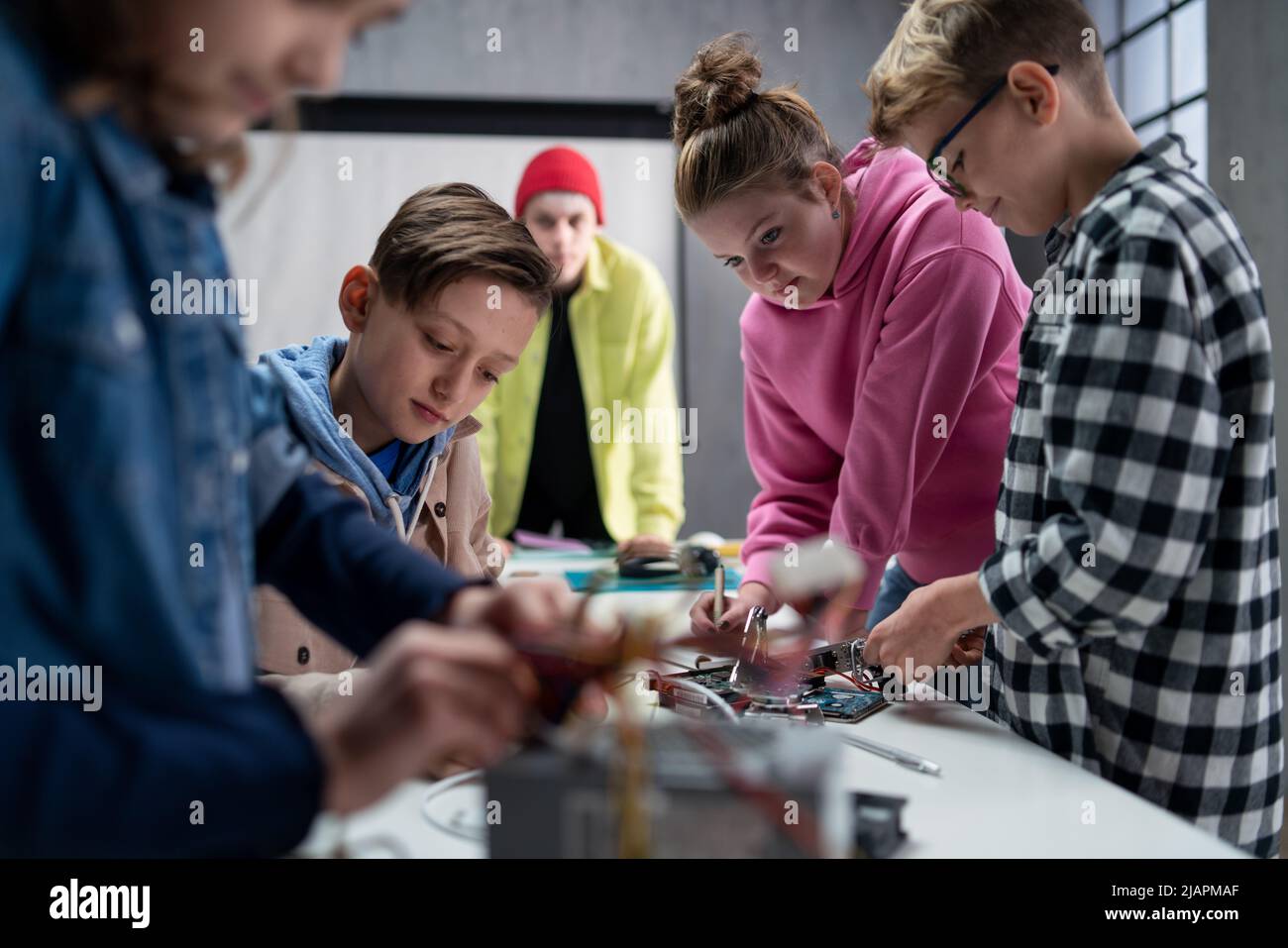 Group of kids working together on project with electric toys and robots ...