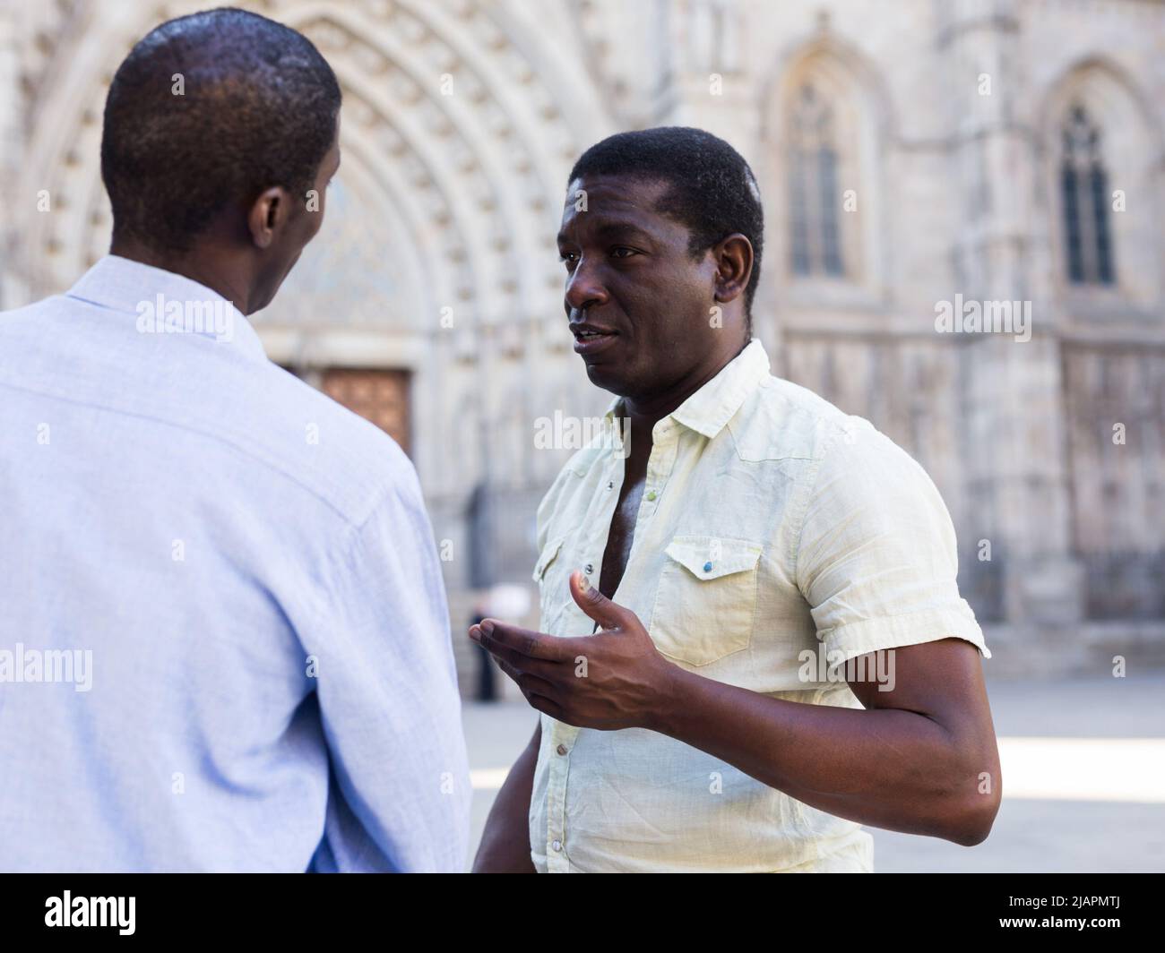 Positive African American talking with friend outdoors Stock Photo - Alamy