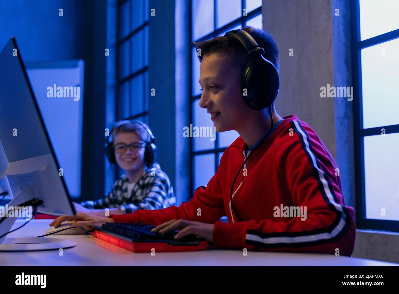 Young gamer boys with headphones playing computer video game Stock ...