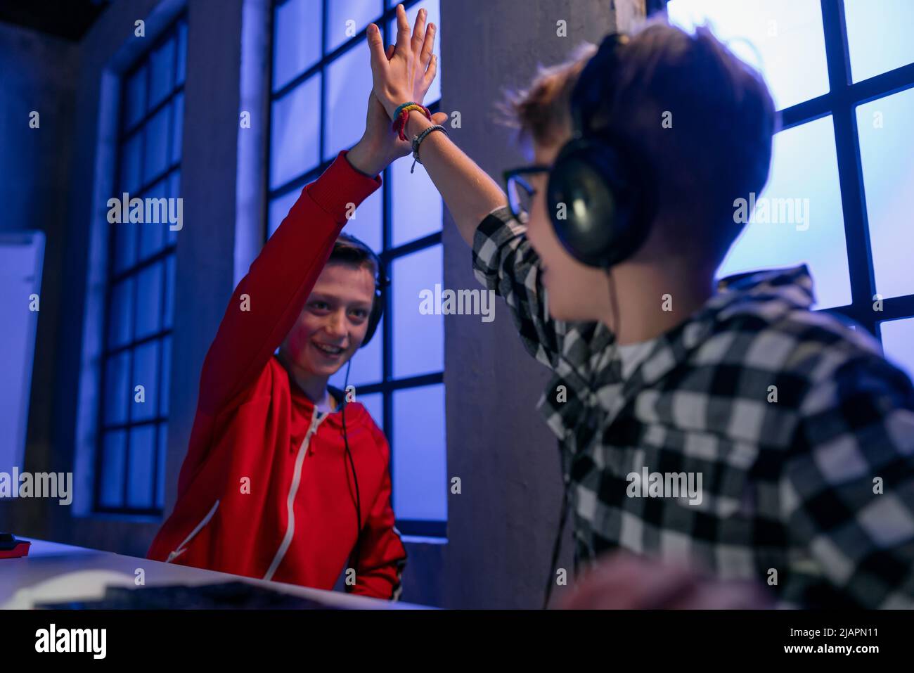 Young gamer boys with headphones playing computer video game Stock ...