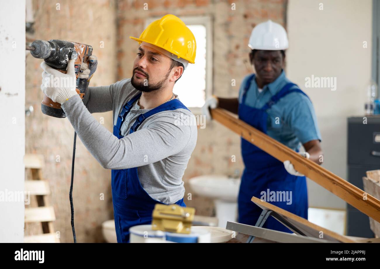 Man builder using electric hammer in construction site Stock Photo - Alamy