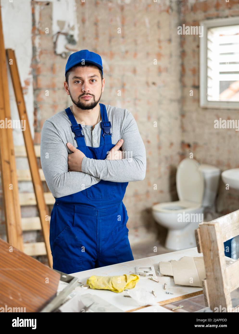 Portrait of builder man in blue overalls in room being renovated Stock ...