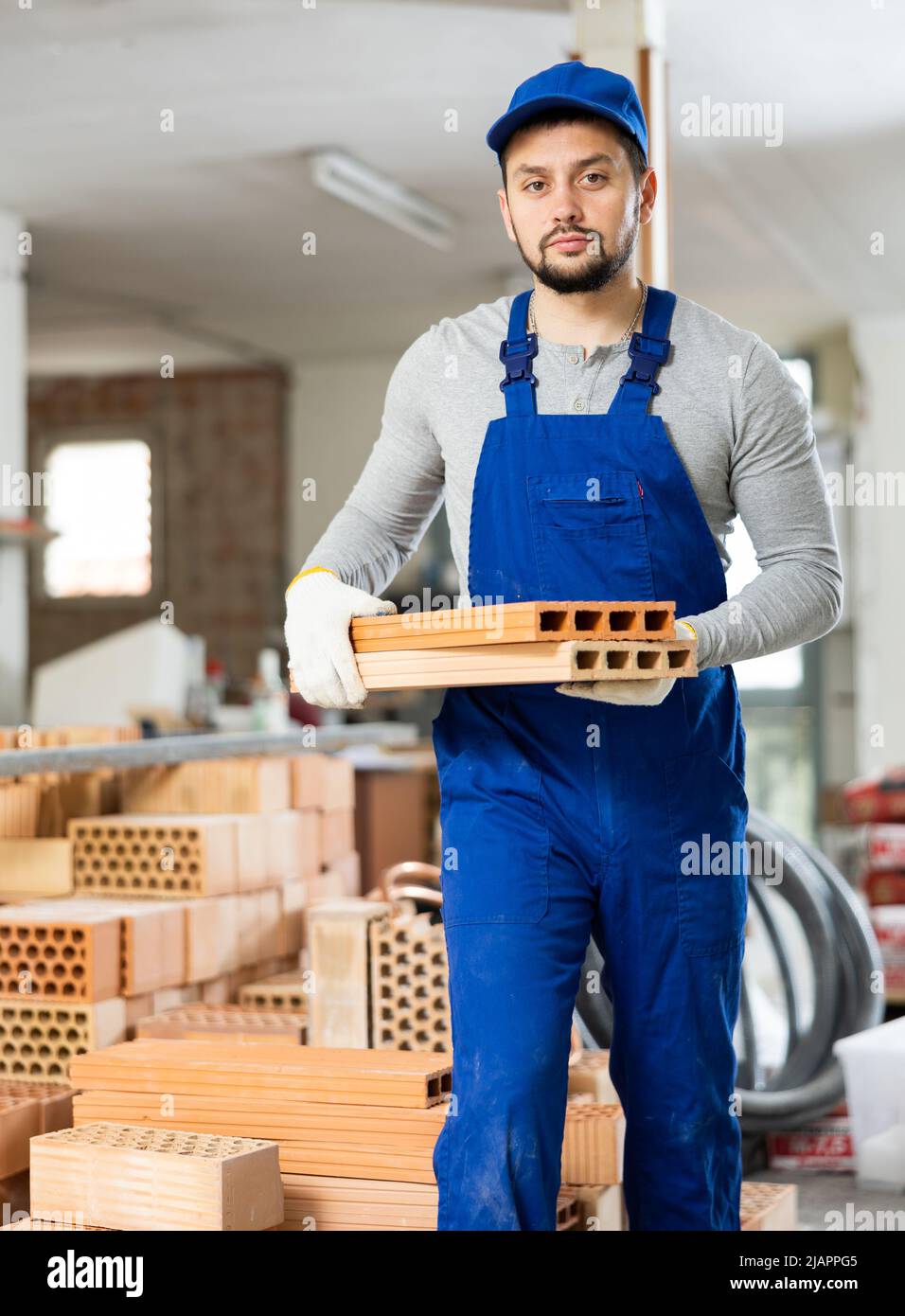Builder holds red brick construction material in his hands Stock Photo ...