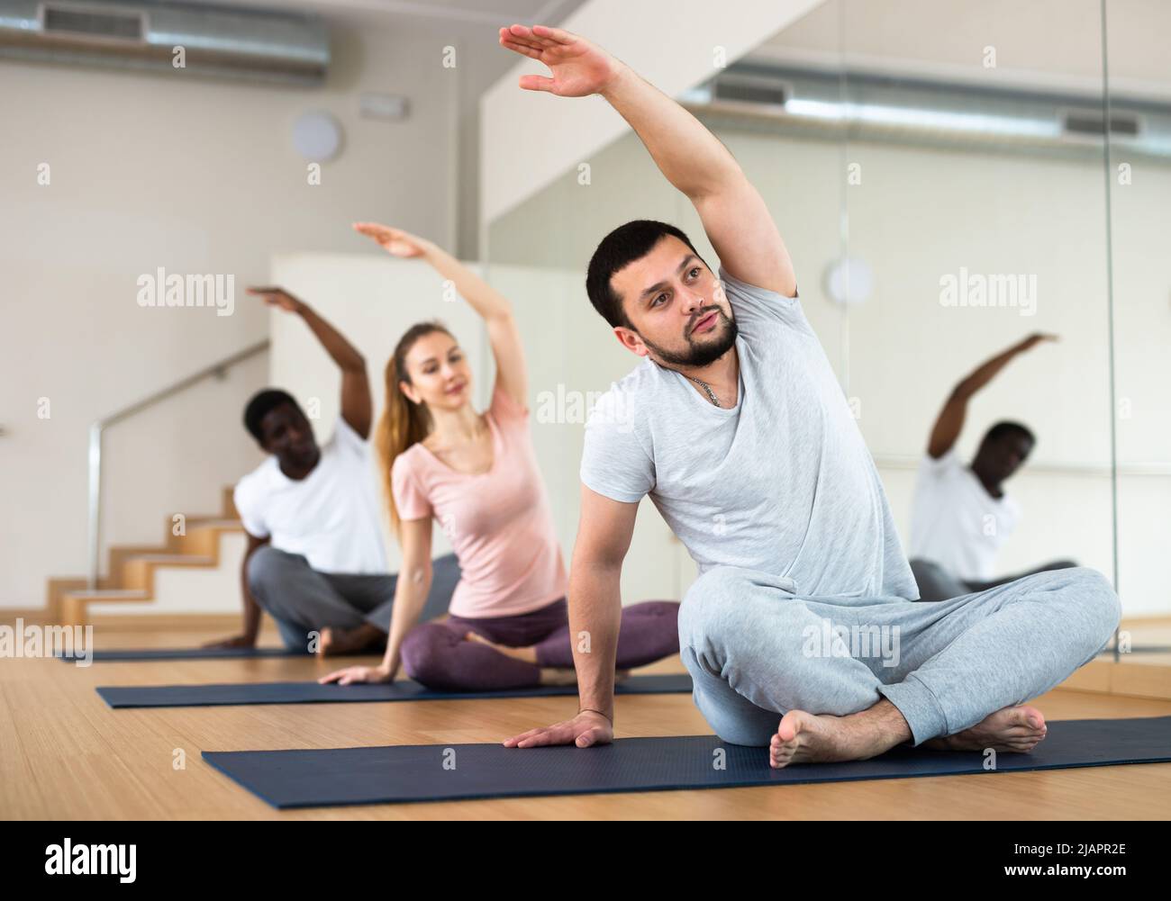 Young man doing stretching exercises in lotus position Stock Photo - Alamy