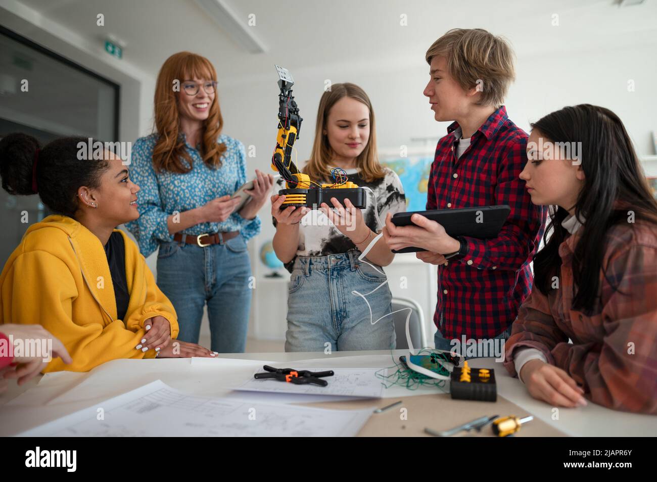 Group of students building and programming electric toys and robots at ...