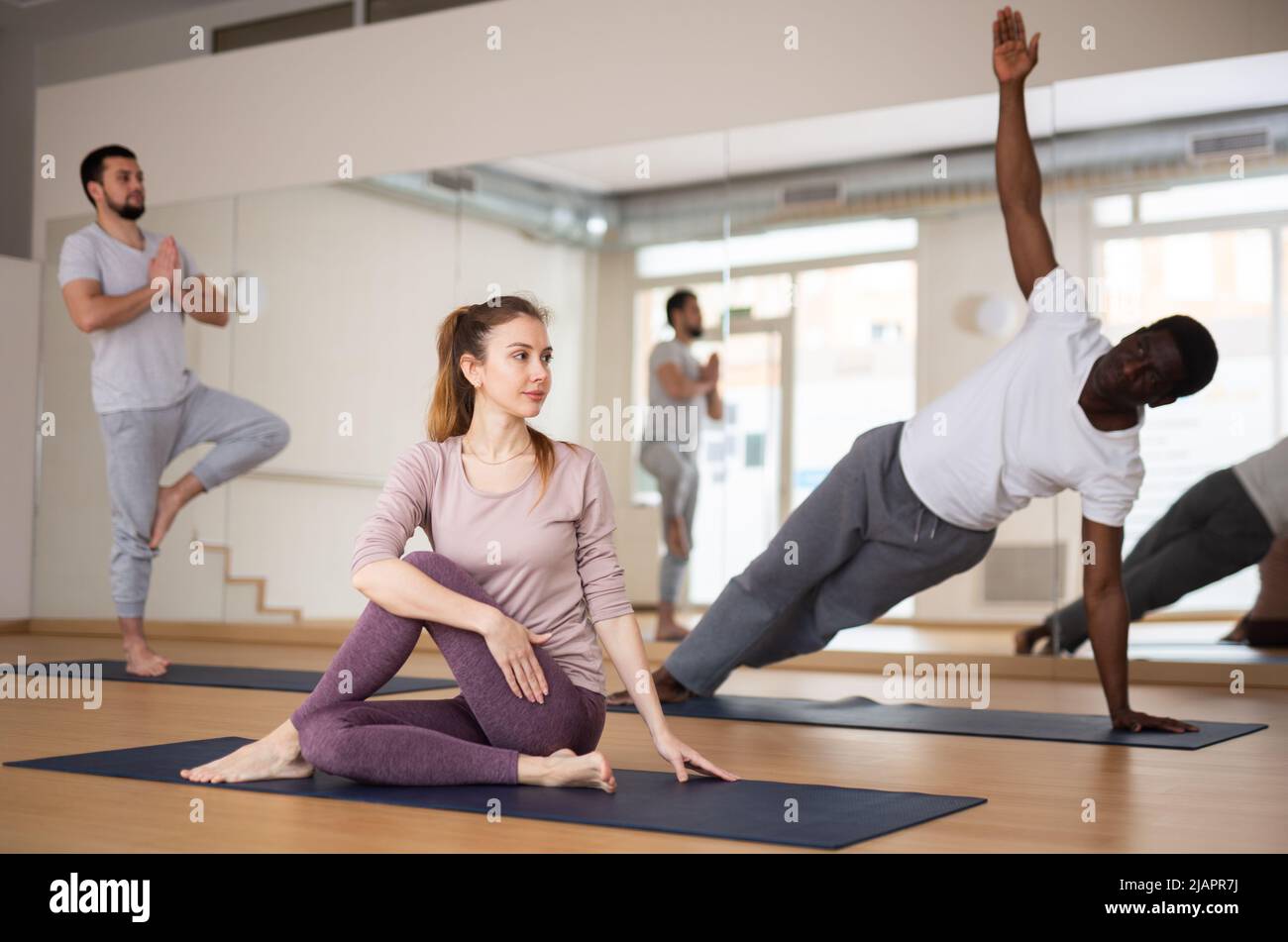 Woman sitting in twisting asana Matsyendrasana in fitness studio Stock ...