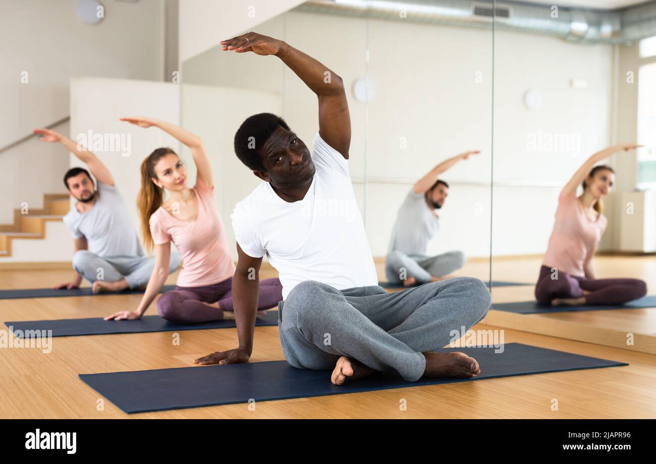 African American Doing Side Bend Stretching In Padmasana Pose Stock
