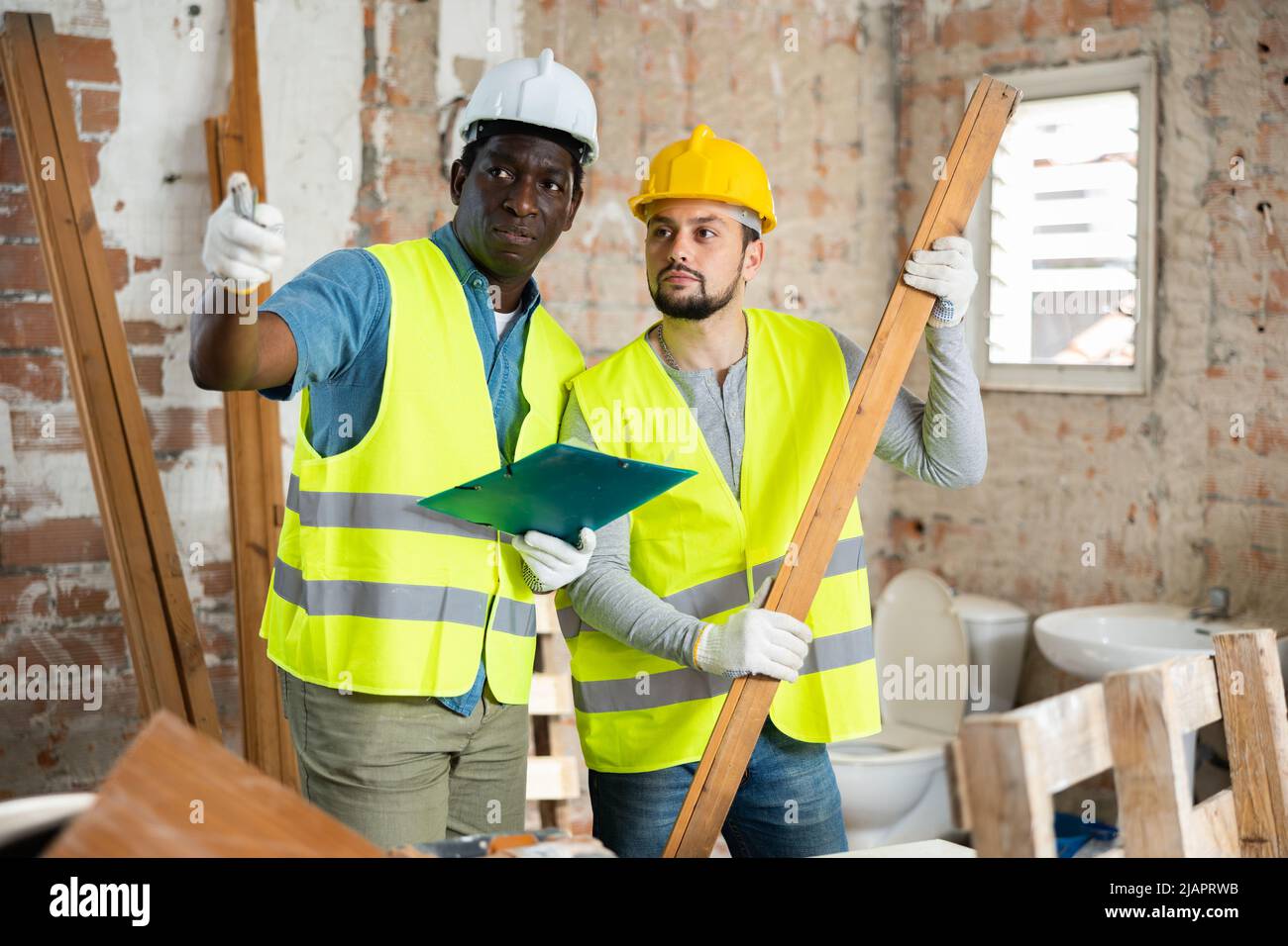 Two builders take notes, evaluating the work plan Stock Photo - Alamy