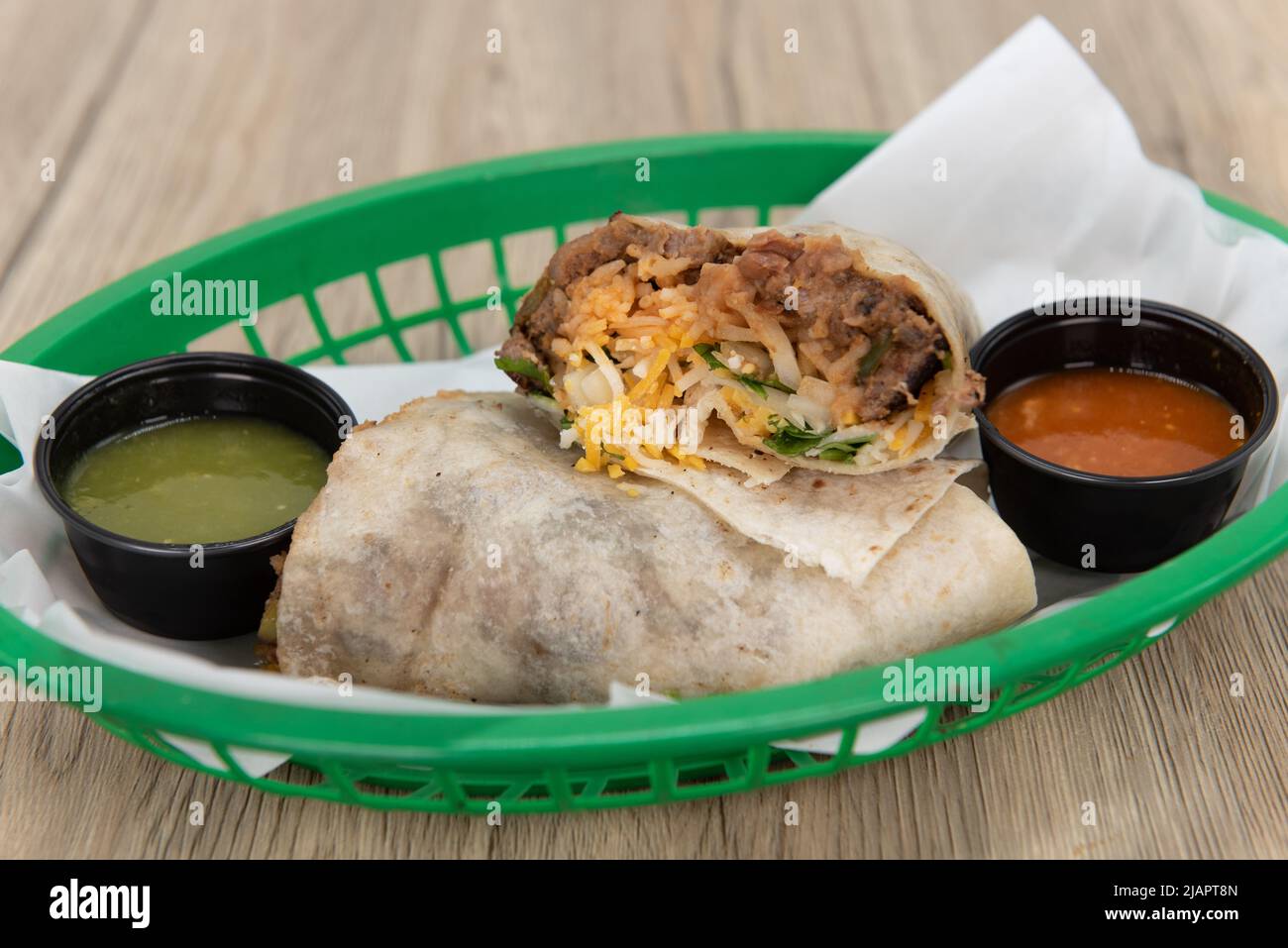 Loaded asada burrito cut in half exposes steak, rice, and beans served ...