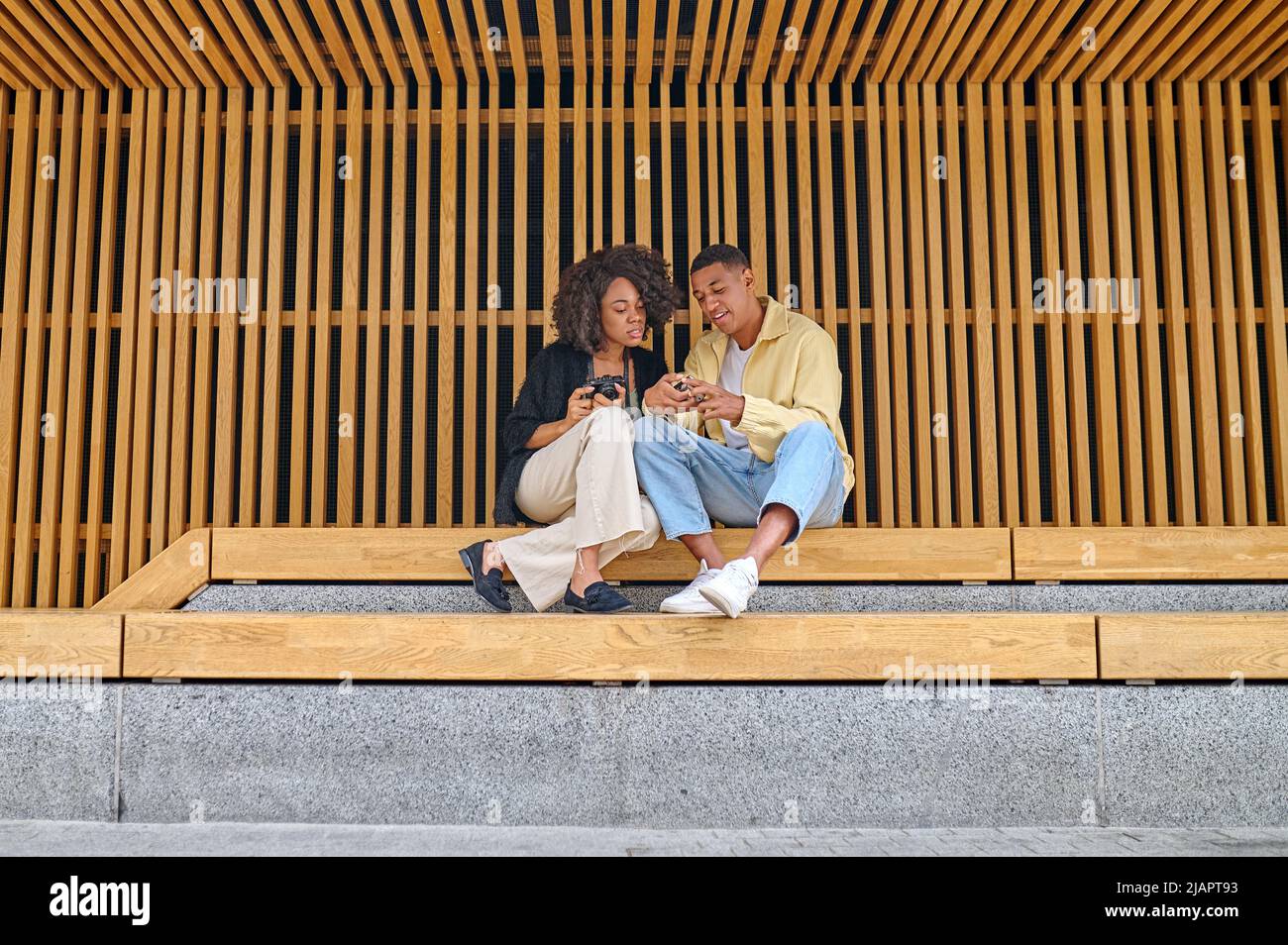 Guy showing photo in camera to interested girl Stock Photo - Alamy
