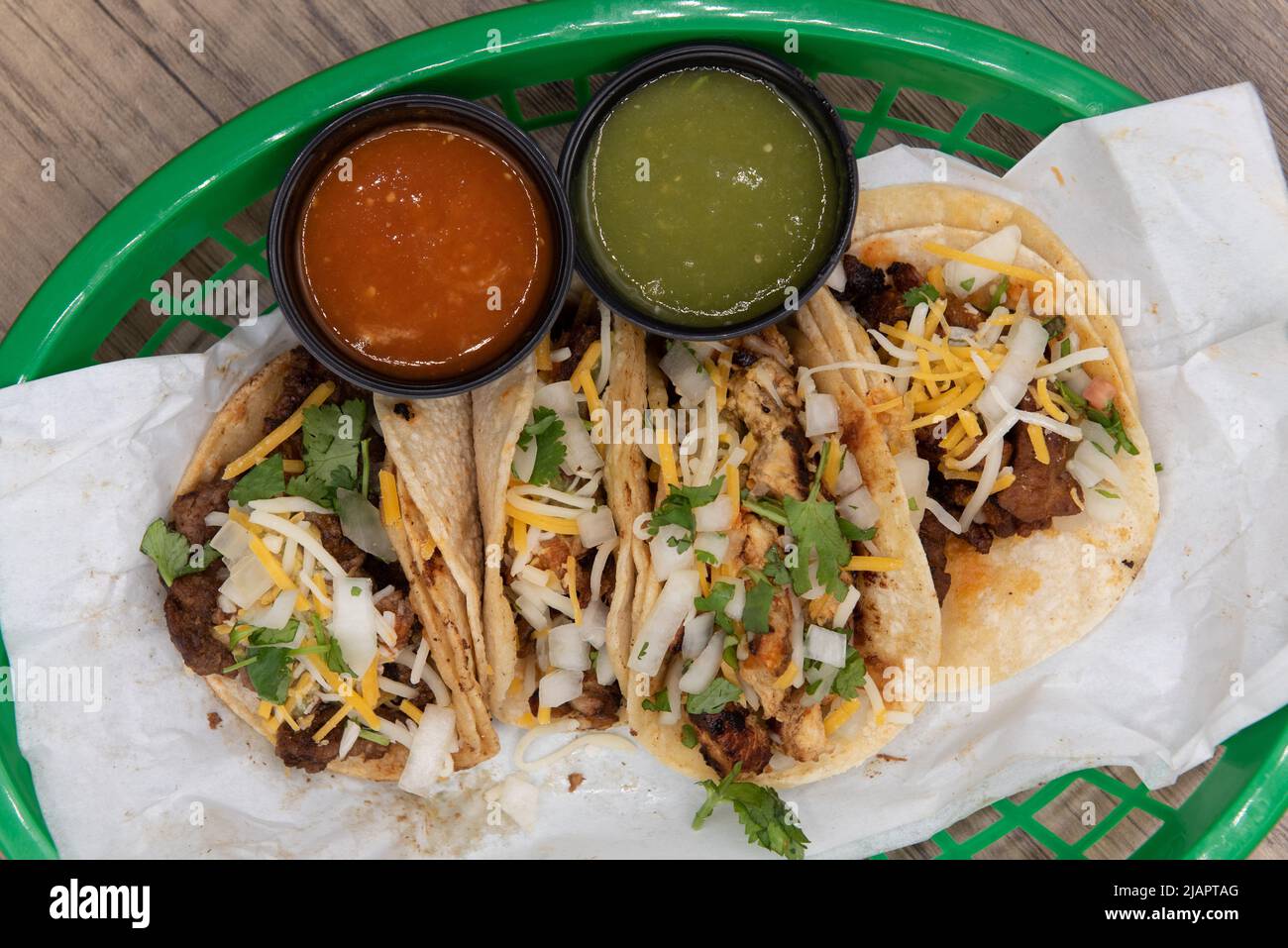 Overhead view of loaded variety of tacos including chicken, steak, and ...
