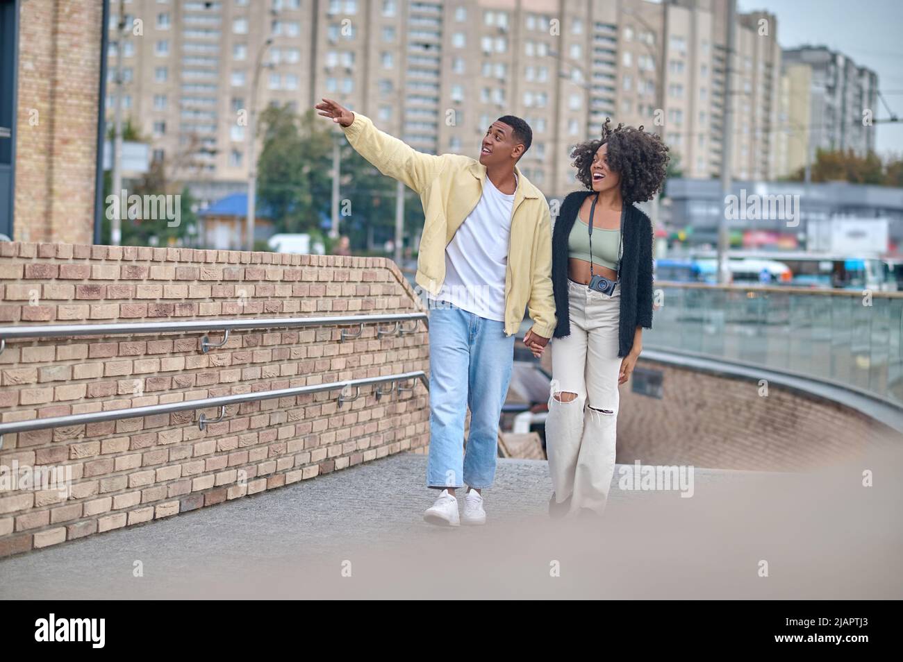 Guy gesturing with hand to side and surprised girl Stock Photo - Alamy