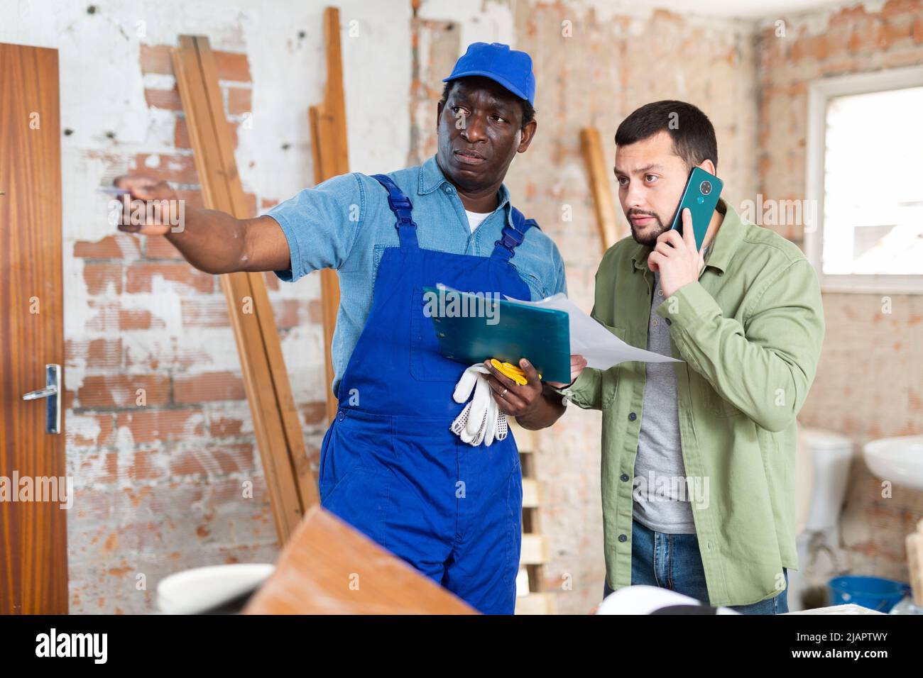 Builder having conversation with designer about working plan Stock ...