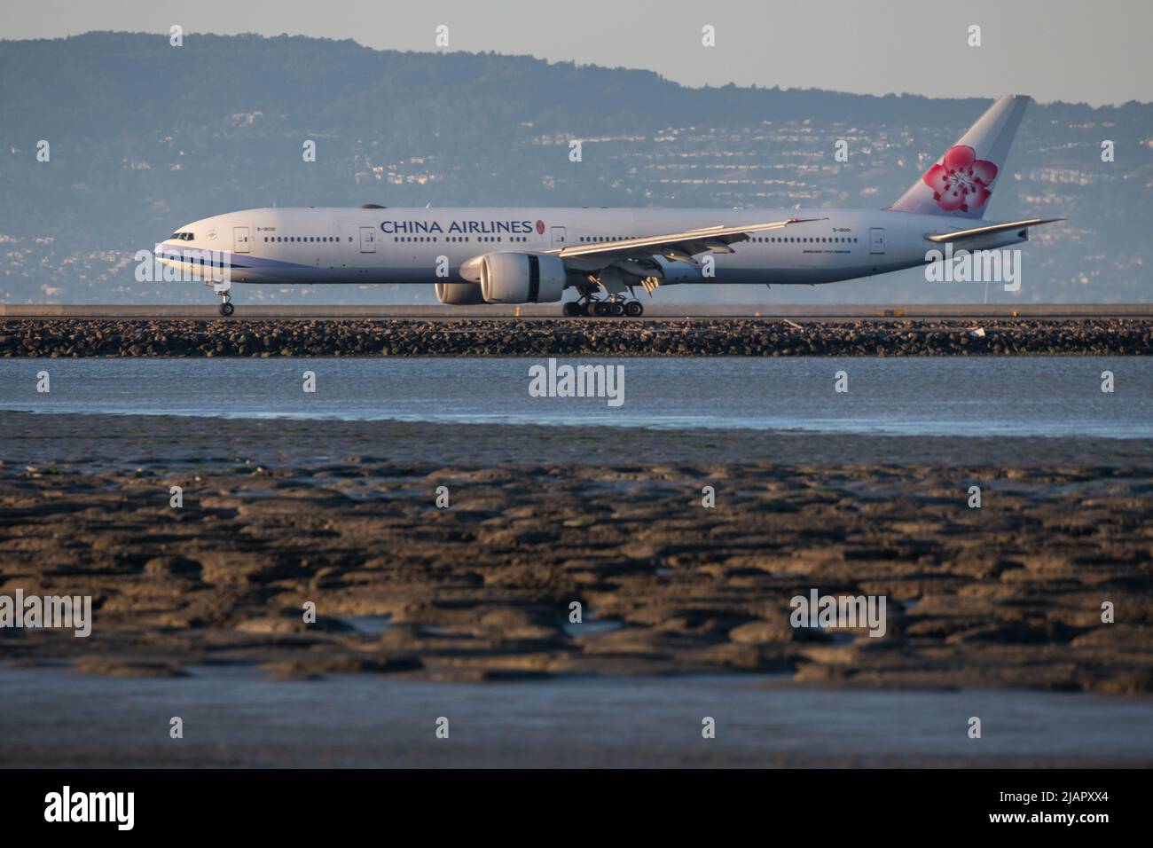 A plane from China Airlines on the runway above a mudflat at San ...