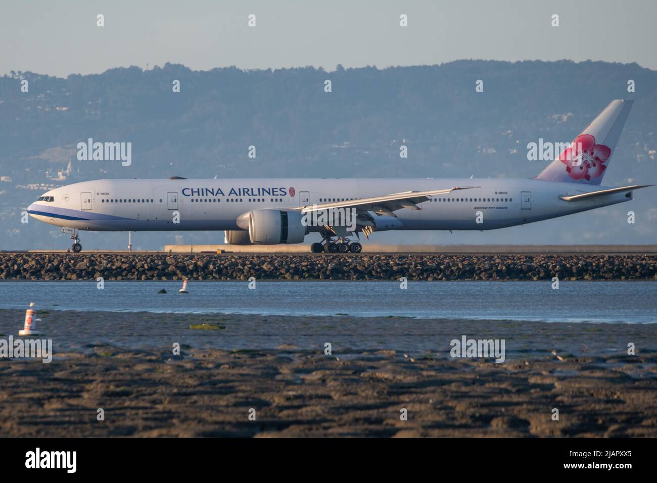 A plane from China Airlines on the runway above a mudflat at San ...