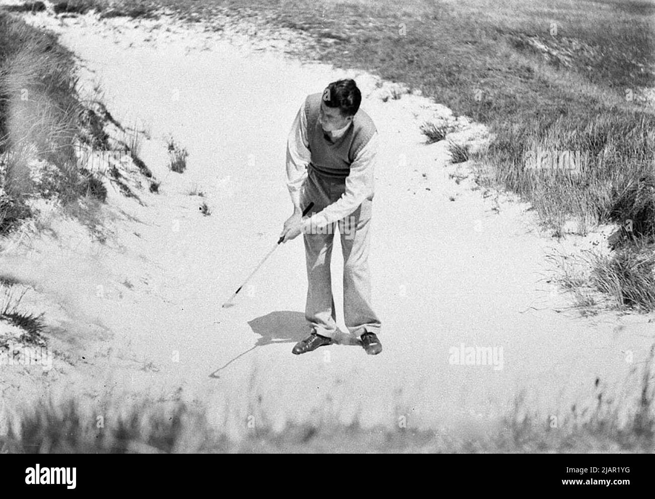 Golfer Tim Bourke playing a golf ball in a sand trap ca. 1934 Stock ...