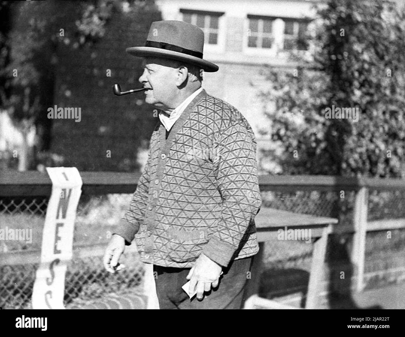 Man smoking a pipe, walking outdoors, facing left ca. 1935 Stock Photo ...