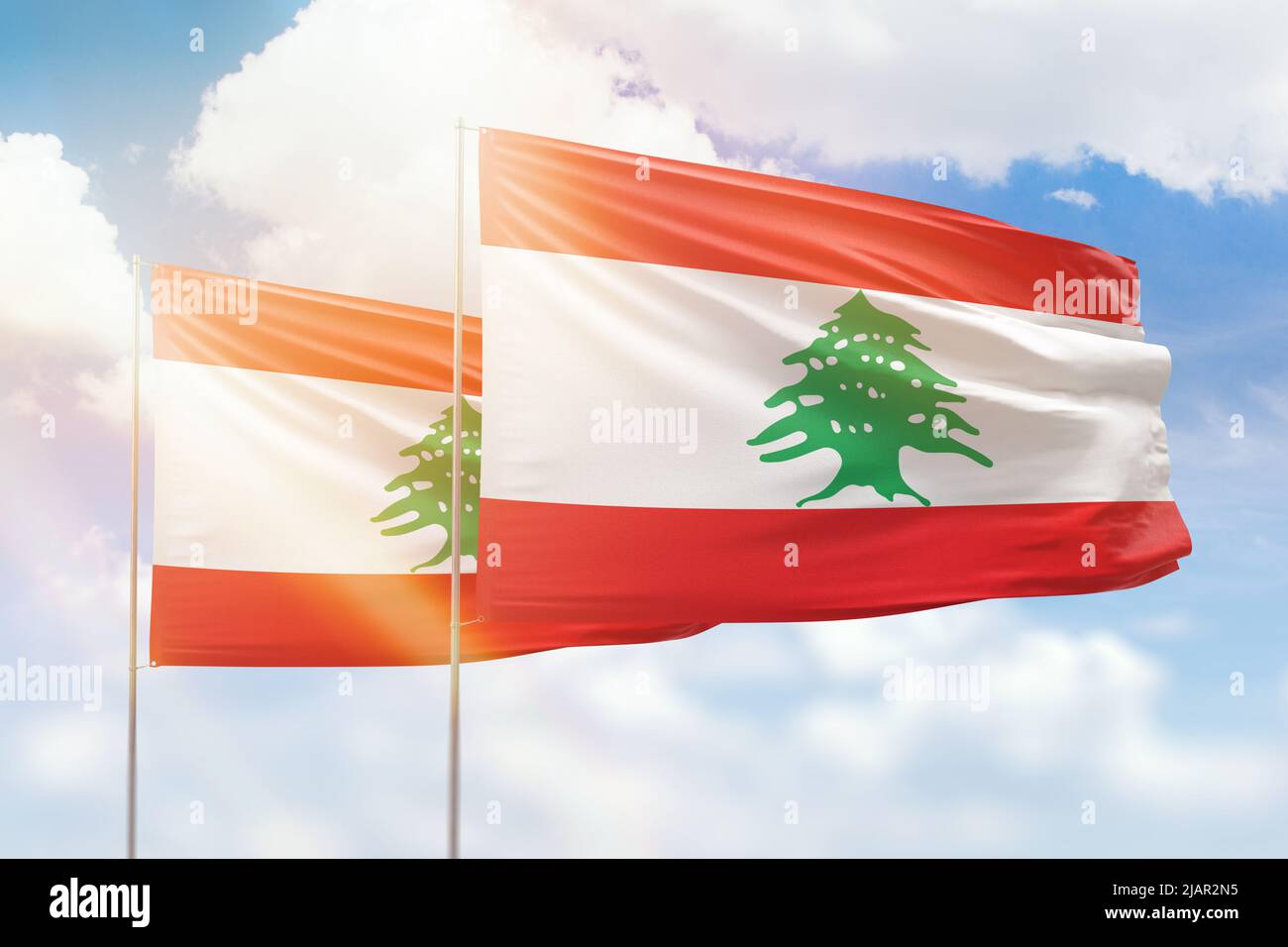 Sunny blue sky and flags of lebanon and lebanon Stock Photo - Alamy