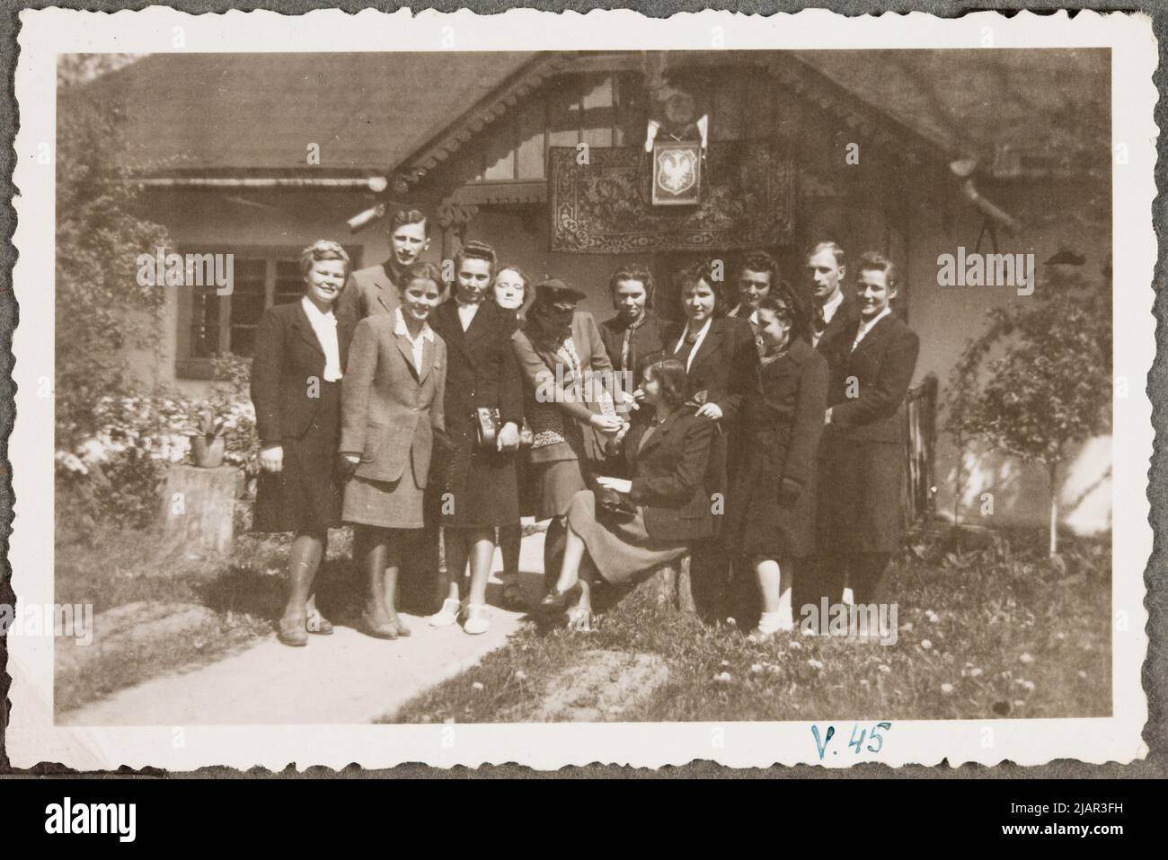 A group of young people, mostly standing, against the background of a ...