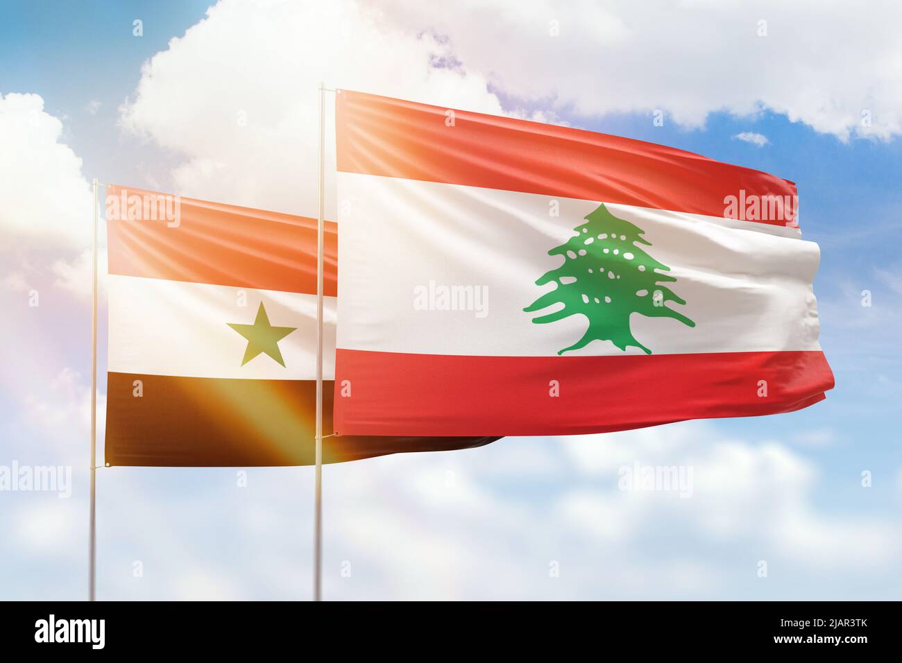 Sunny blue sky and flags of lebanon and syria Stock Photo - Alamy