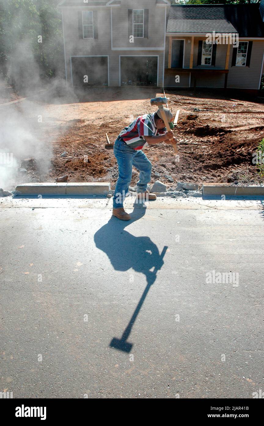 using Bobcat and hand sledge sledgehammers to level and clean dirt site ...