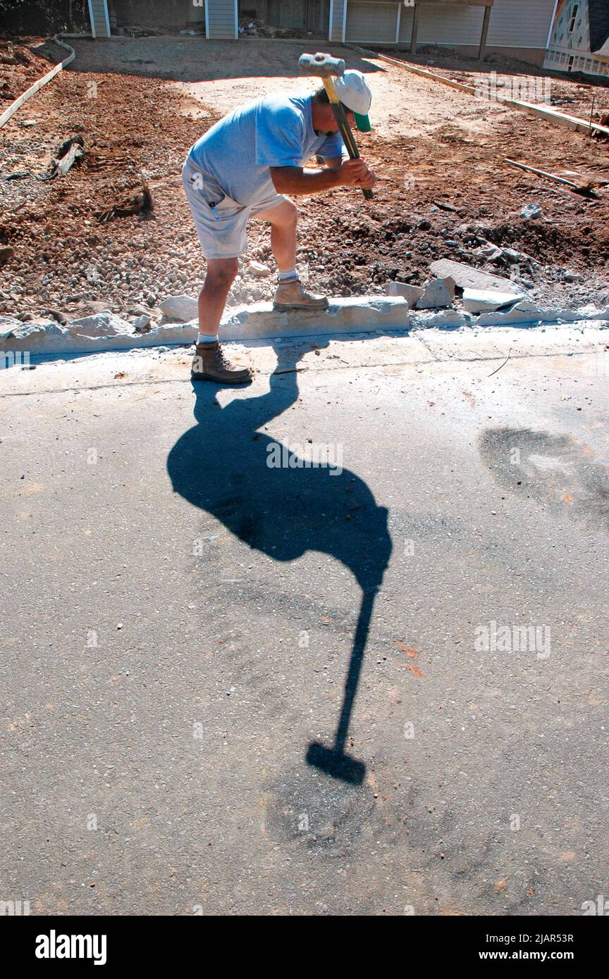 using Bobcat and hand sledge sledgehammers to level and clean dirt site ...