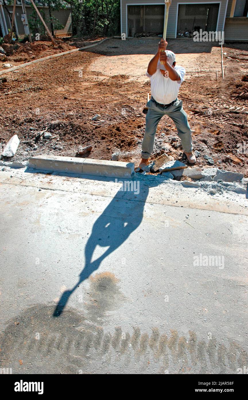 using Bobcat and hand sledge sledgehammers to level and clean dirt site ...