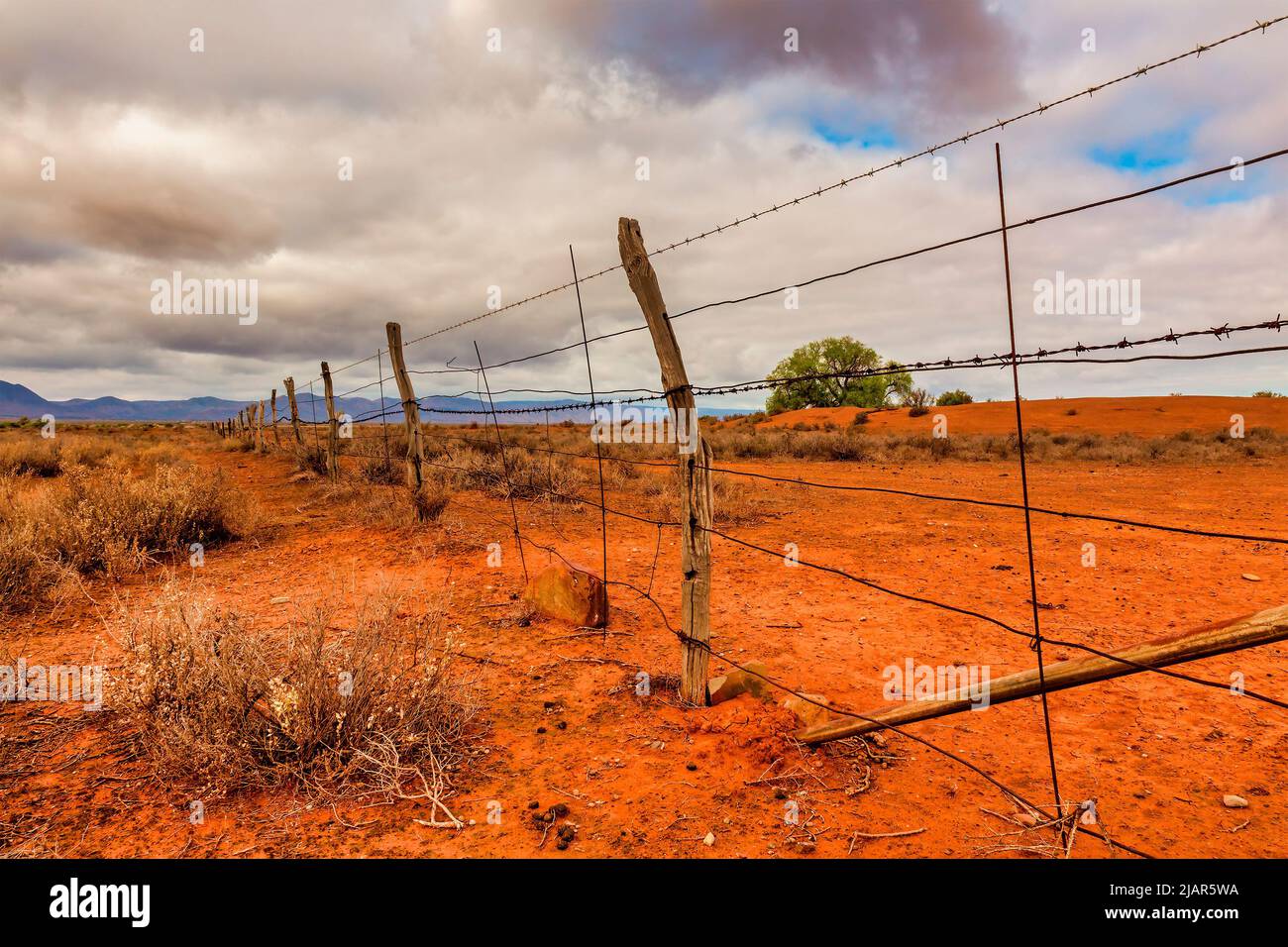 Weathered old posts and wire fence in the harsh Australian outback ...