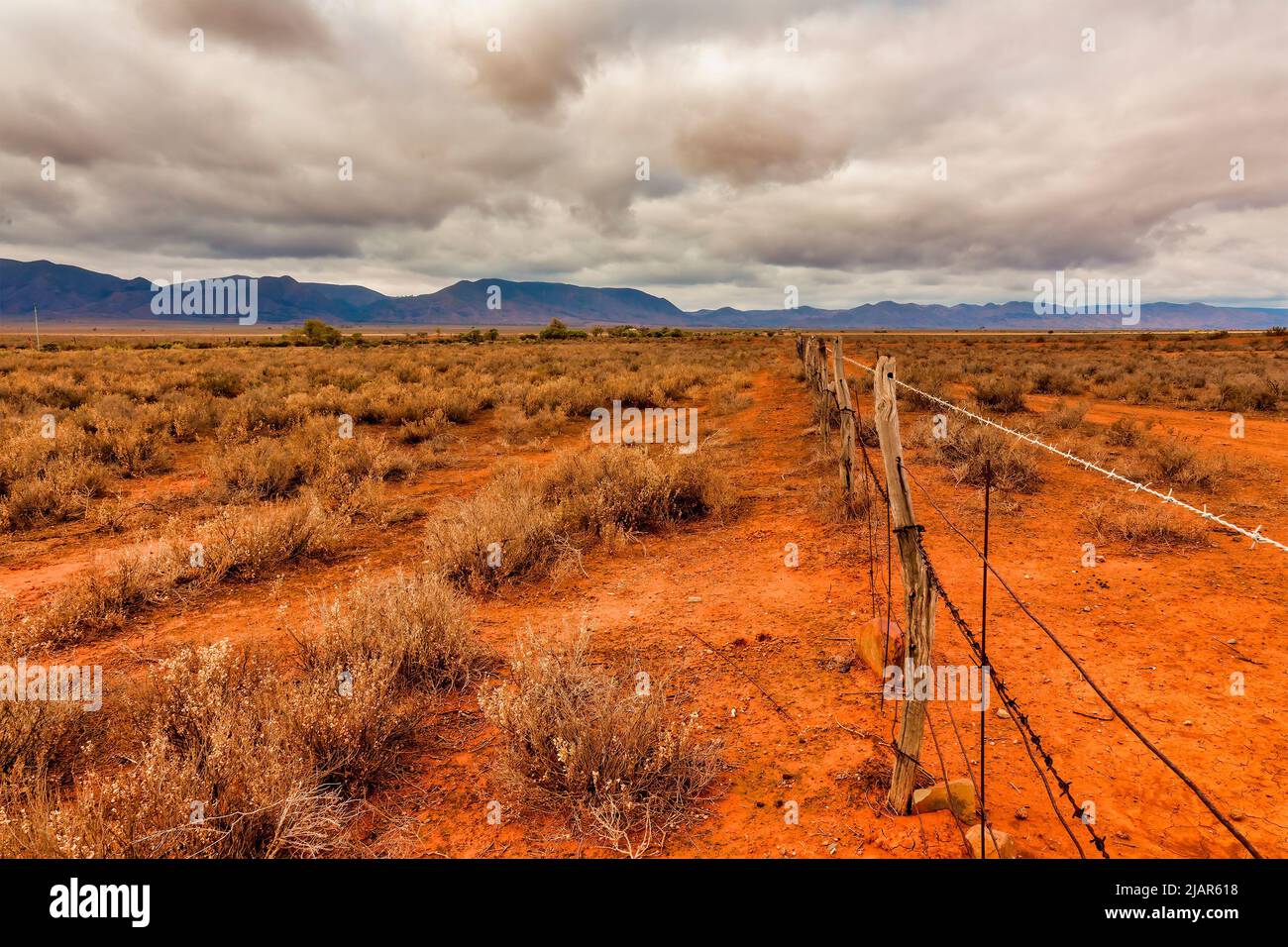 Weathered old posts and wire fence in the harsh Australian outback ...