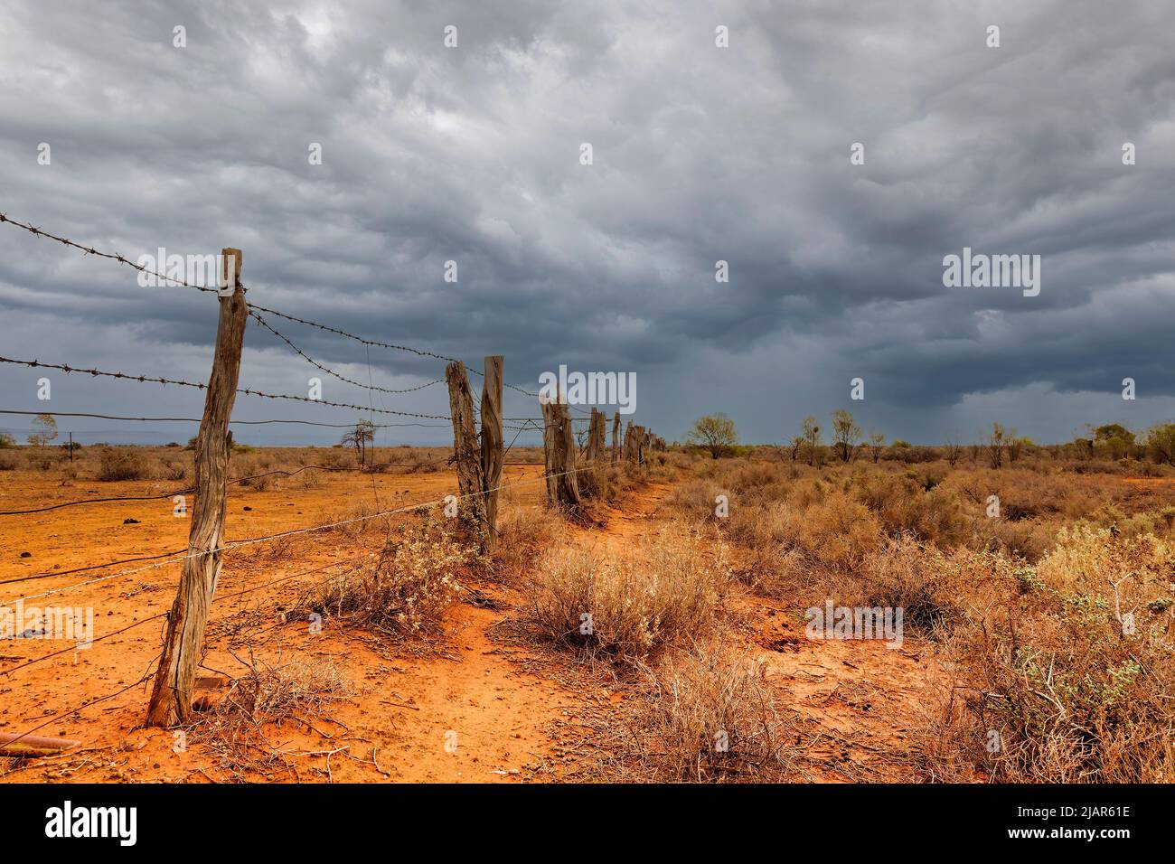 Weathered old posts and wire fence in the harsh Australian outback ...