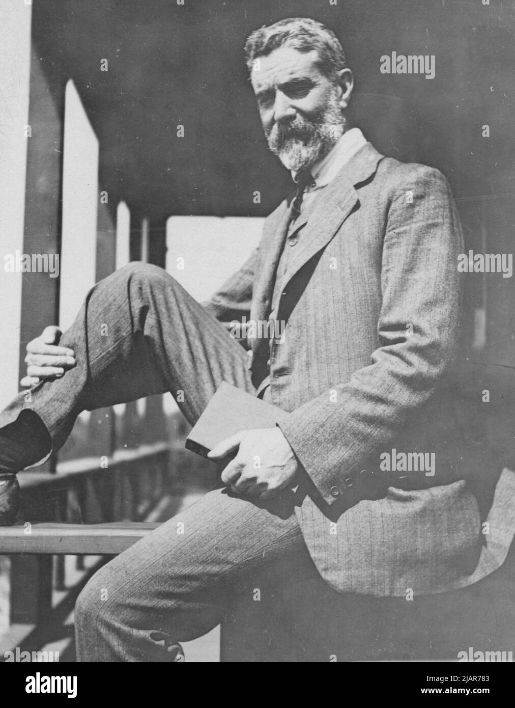 Candid photograph of Alfred Deakin in old age, seated on a verandah and ...