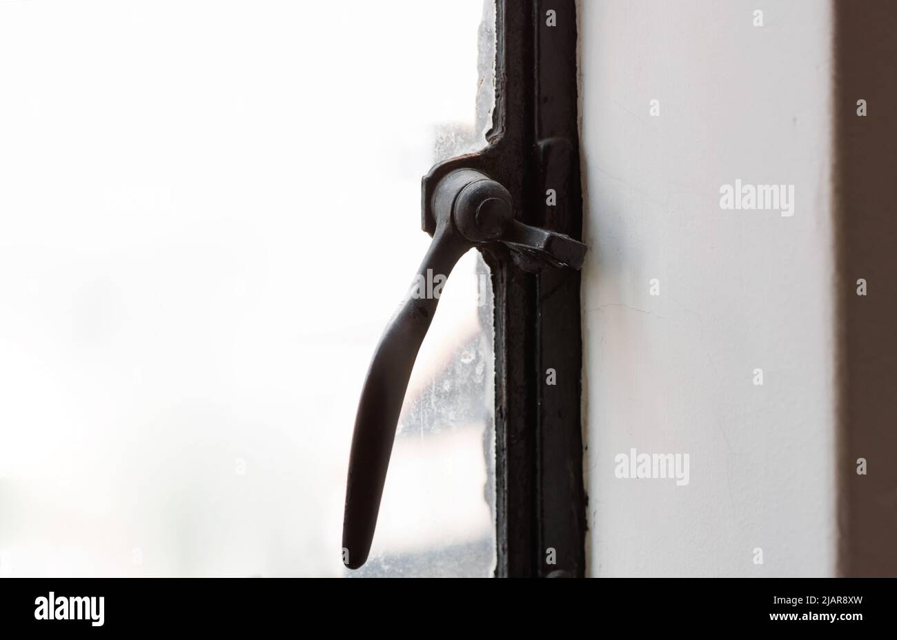 close up of the handle and clasp of an antique casement window, with ...