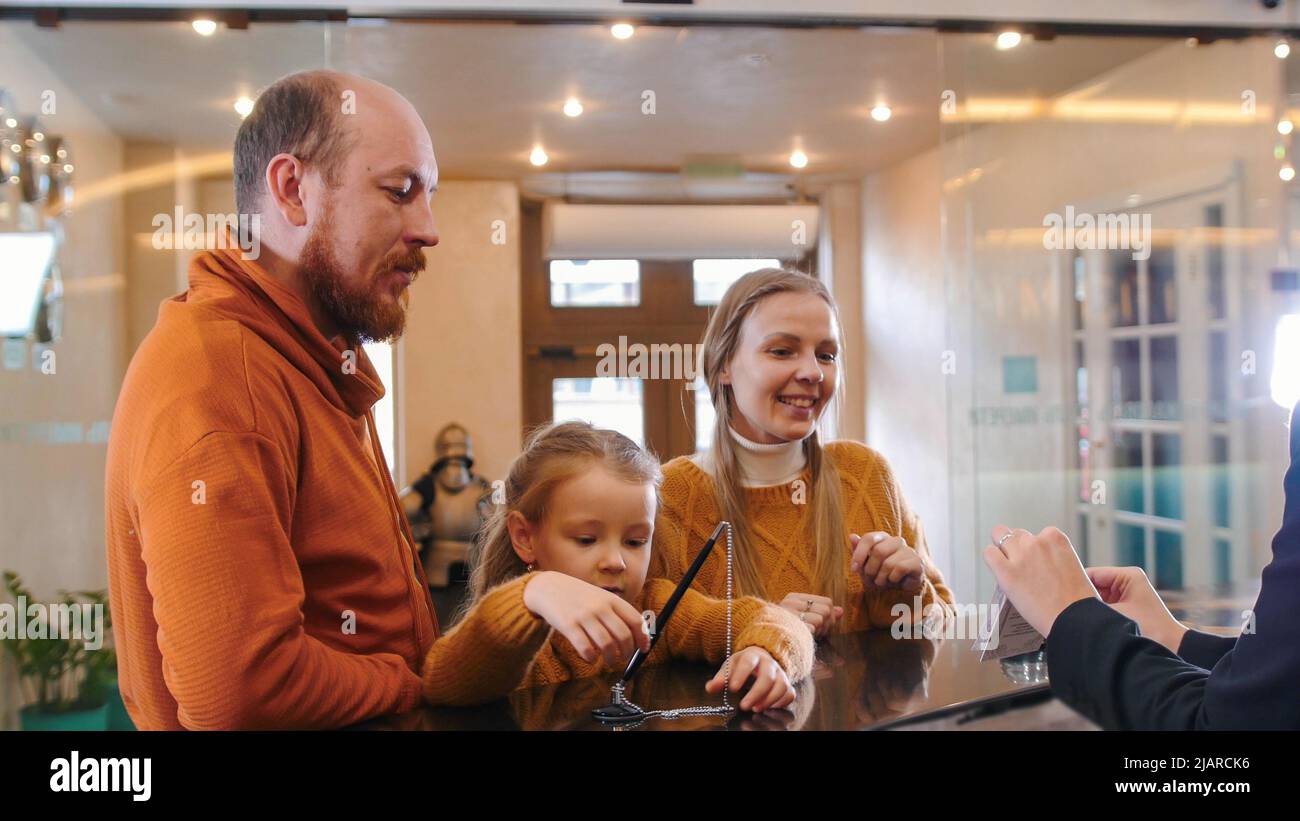 A family checking in the hotel - standing by the reception Stock Photo ...
