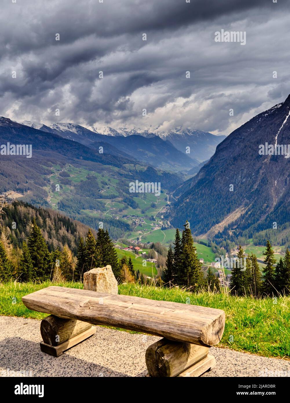 Wooden bench made of rough logs for tired hikers in front of long wide ...