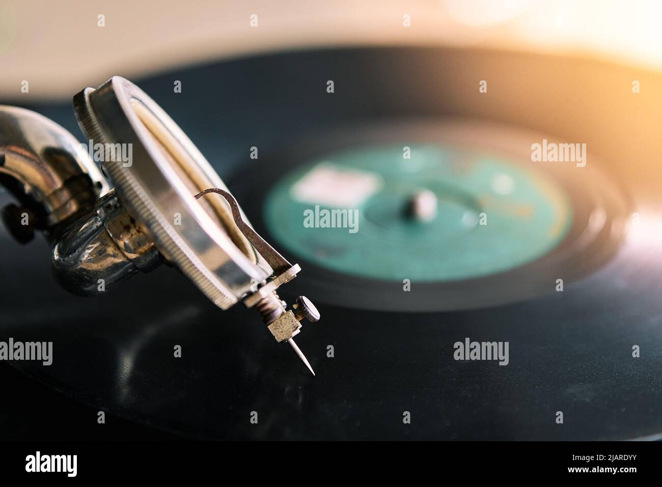 needle of an old portable gramophone with a powder-covered vinyl record ...