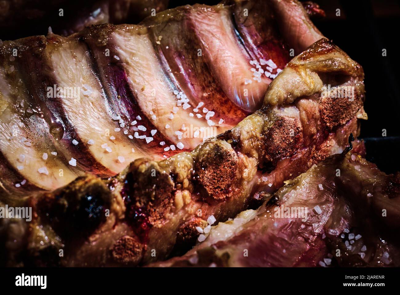 juicy beef rib and pork rib slowly being made on the grill on the fire ...