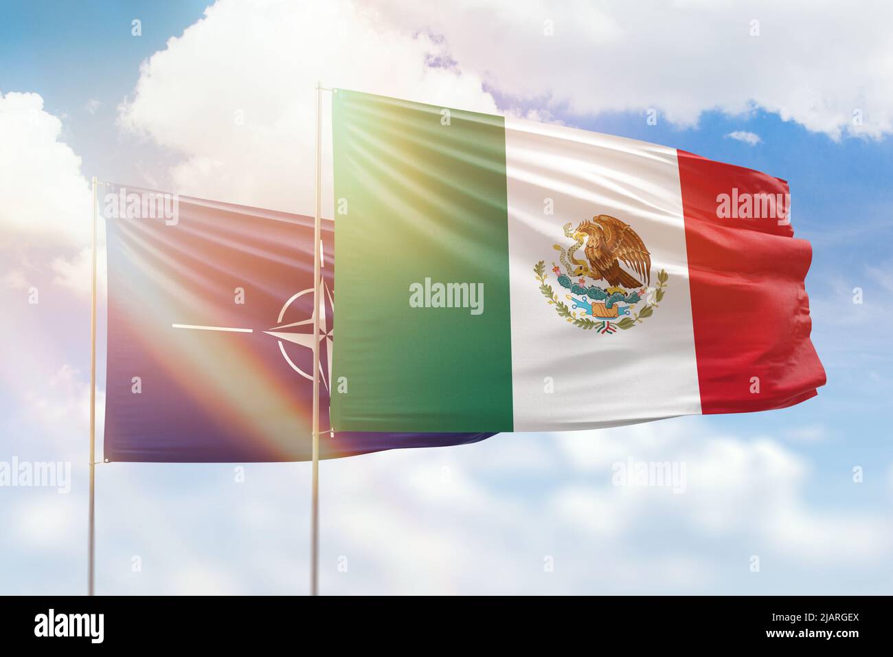 Sunny blue sky and flags of mexico and nato Stock Photo - Alamy