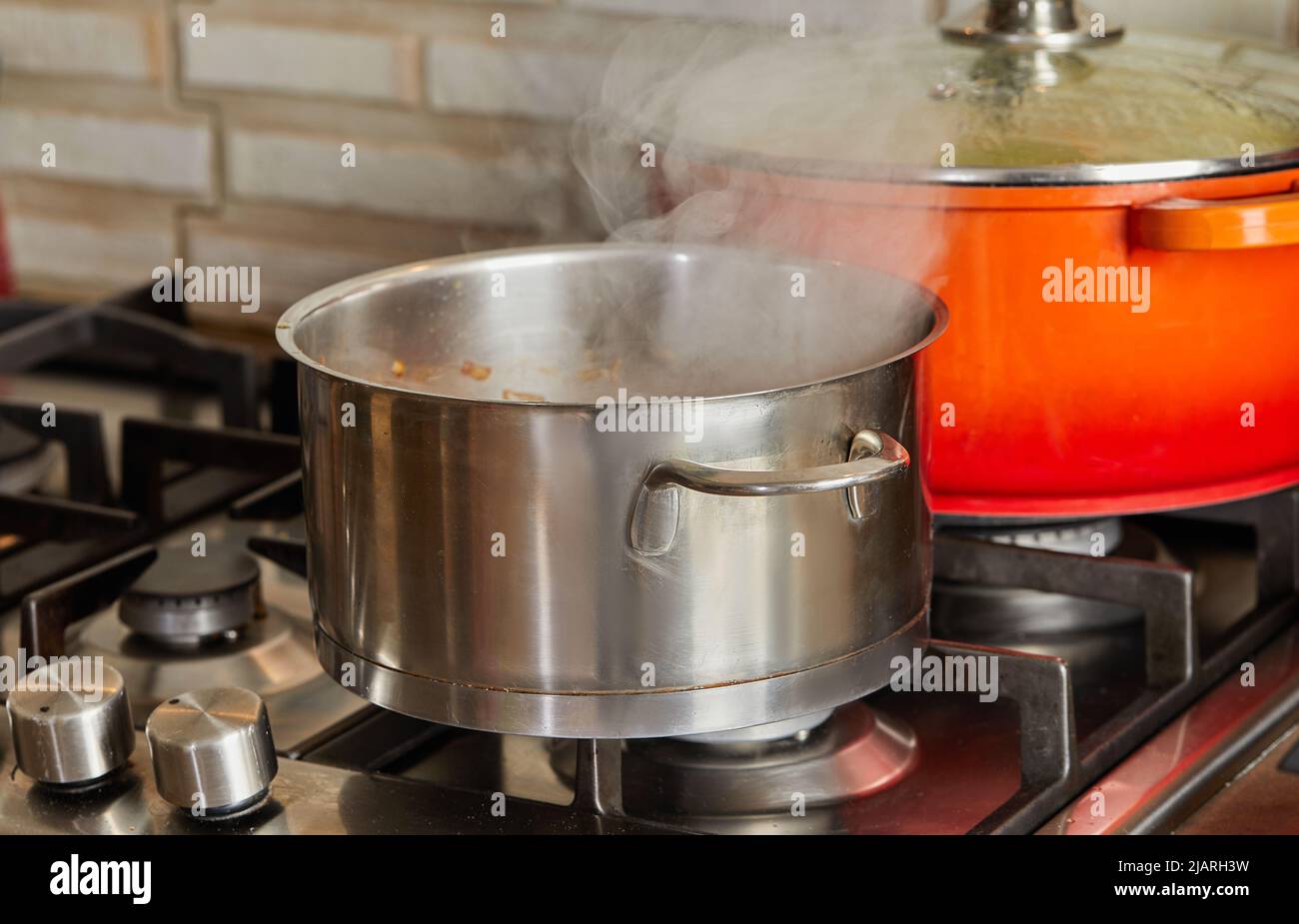 Pots with steam boiling on gas stove in the kitchen Stock Photo - Alamy