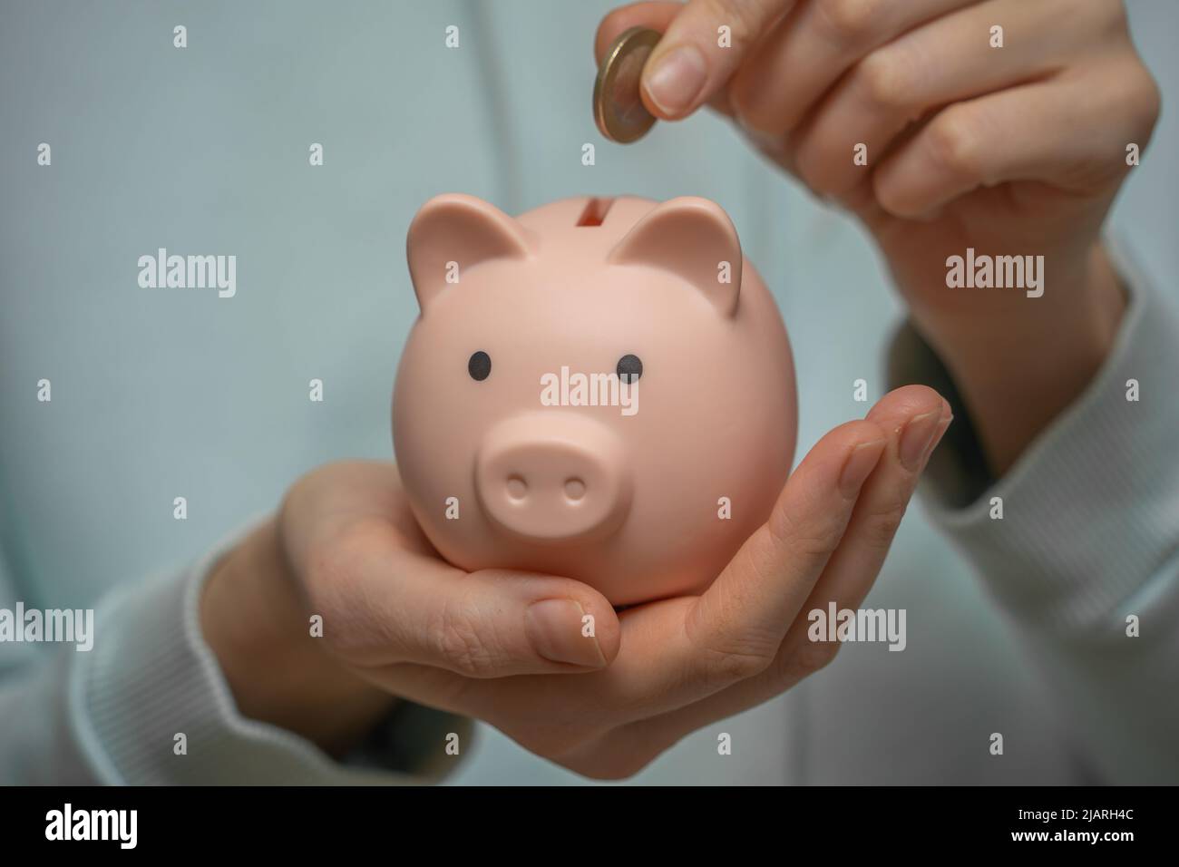 Women's hands hold a piggy bank close-up. Saving and accumulating money ...